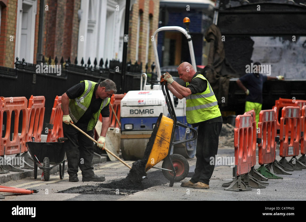 Workmen using tar to repair a road in London Stock Photo - Alamy