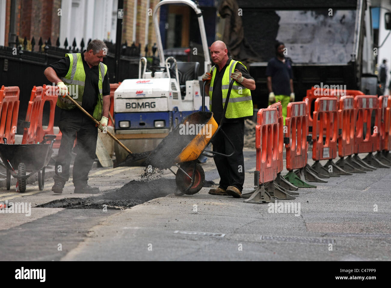 Workmen using tar to repair a road in London Stock Photo - Alamy