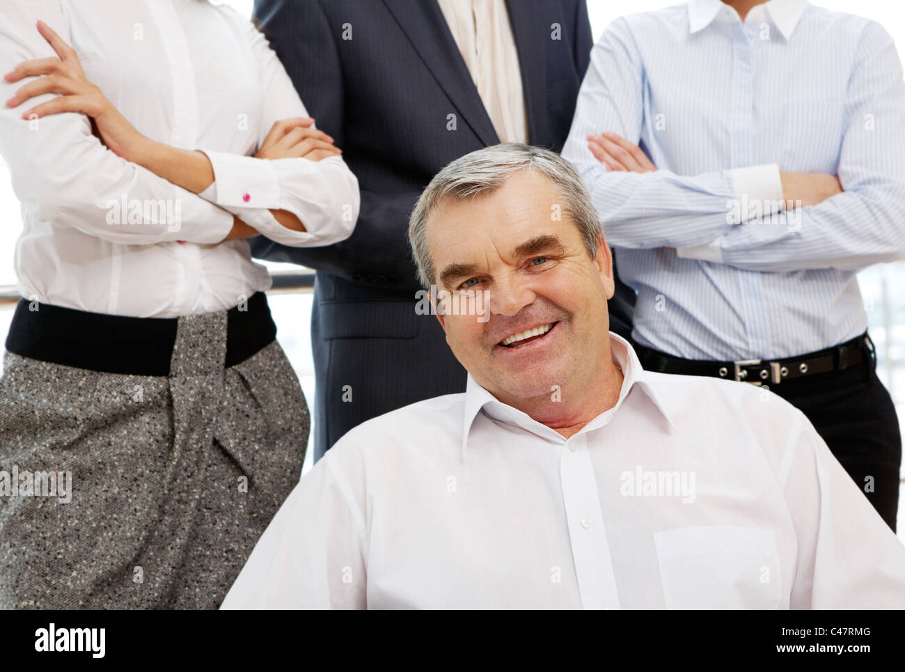 Portrait of confident boss looking at camera with employees behind ...