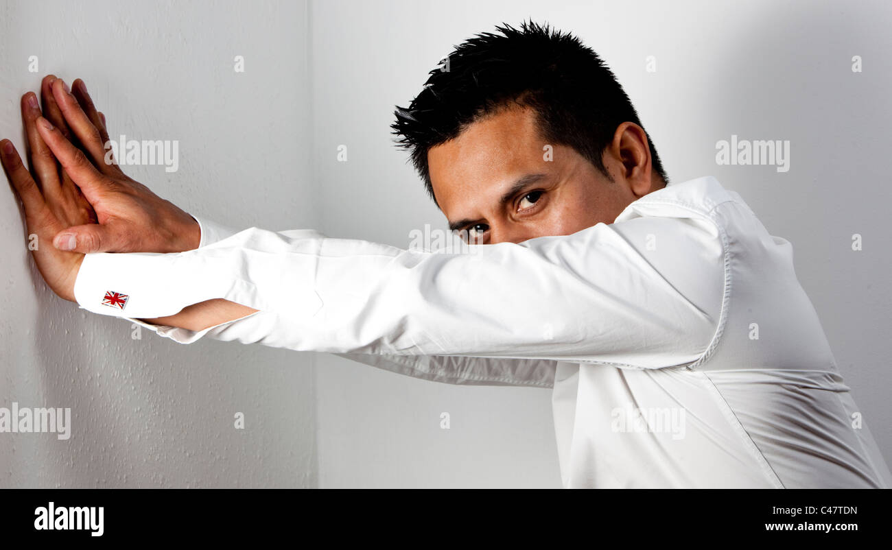 Man looking to the camera with hands against the wall Stock Photo - Alamy