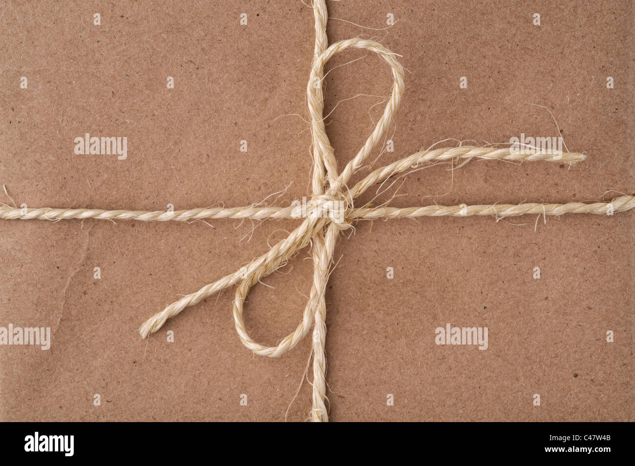 String tied in a bow, on a brown recycled paper package Stock Photo - Alamy