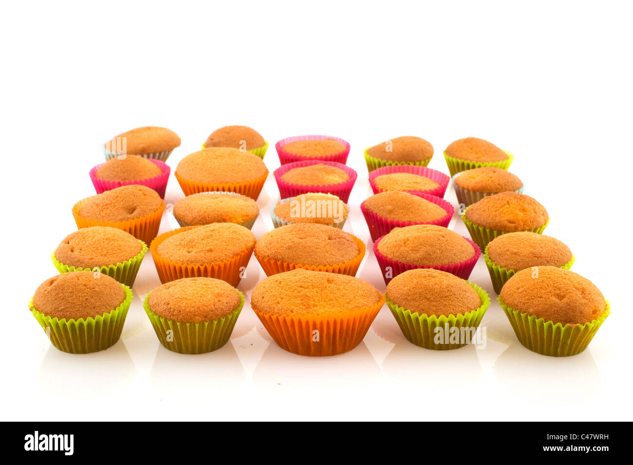 Many colorful muffins stacked and isolated over white Stock Photo - Alamy