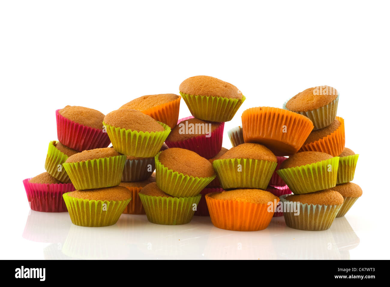 Many colorful muffins stacked and isolated over white Stock Photo - Alamy