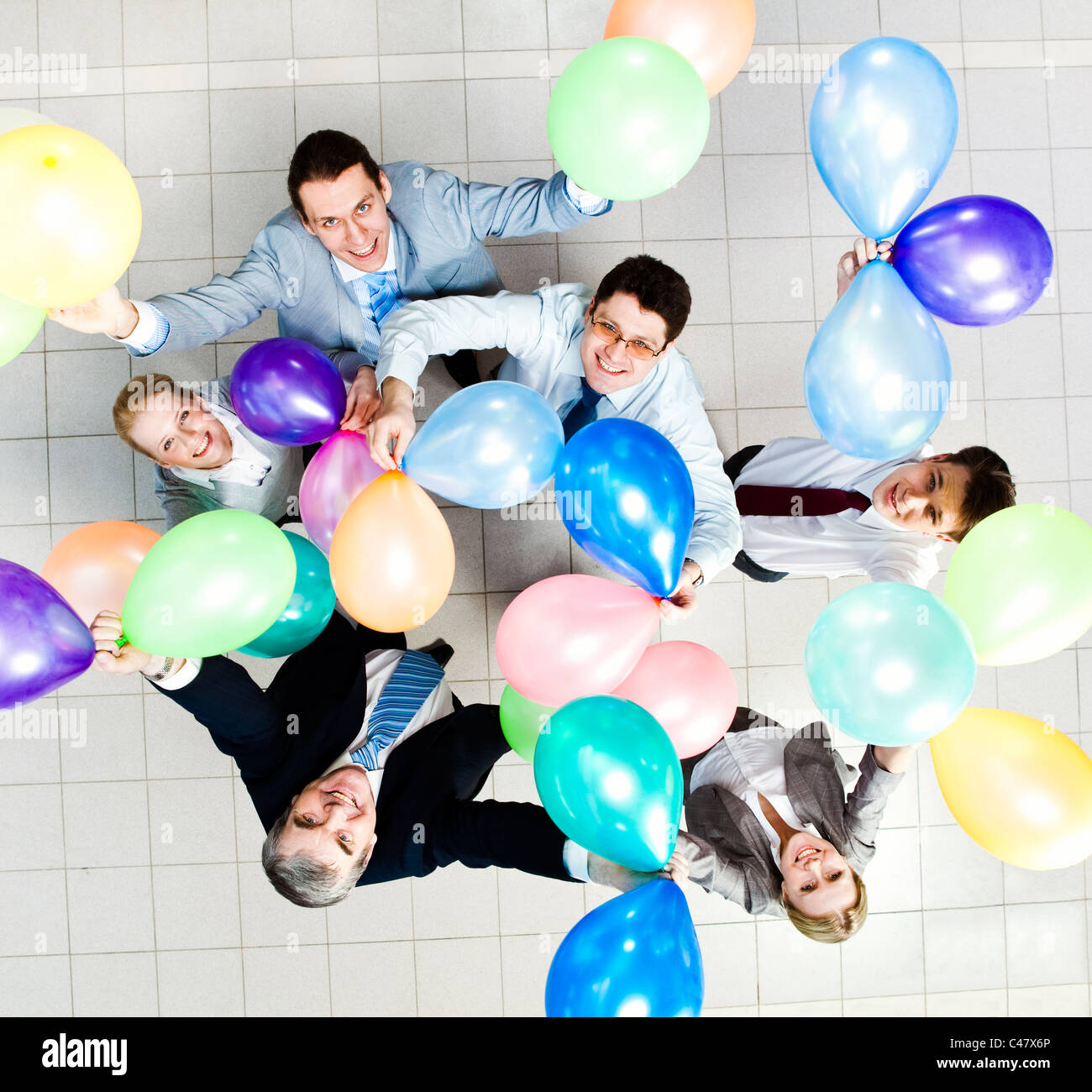 Above view of several successful partners with colorful balloons ...