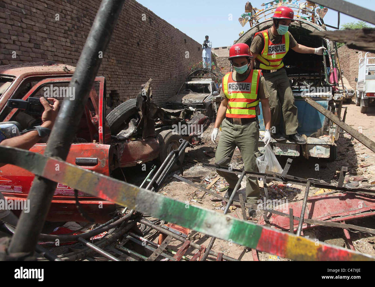 Rescue workers look damaged vehicles which were destroyed in explosion ...