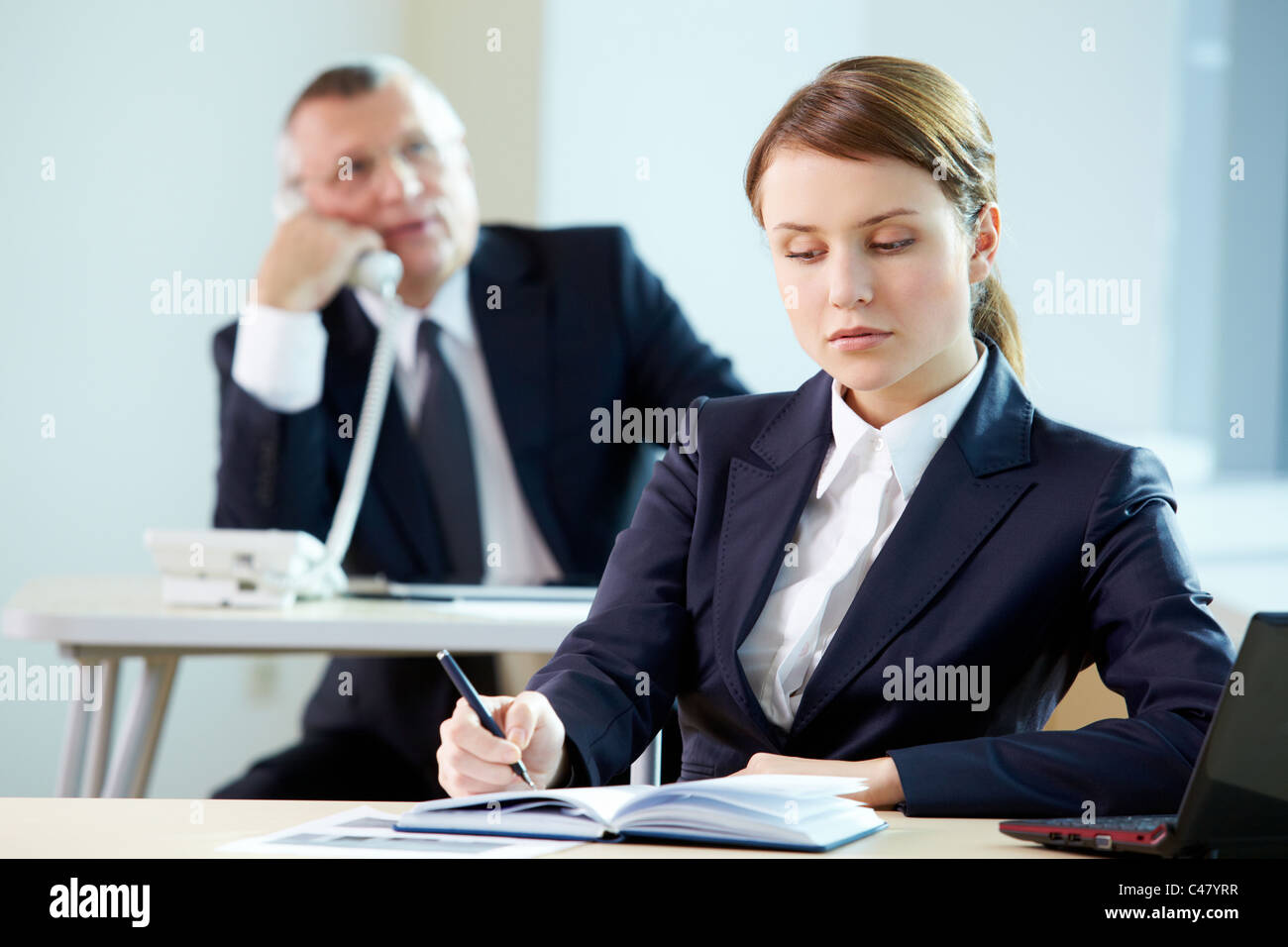 Pensive secretary writing plan of work at workplace Stock Photo - Alamy