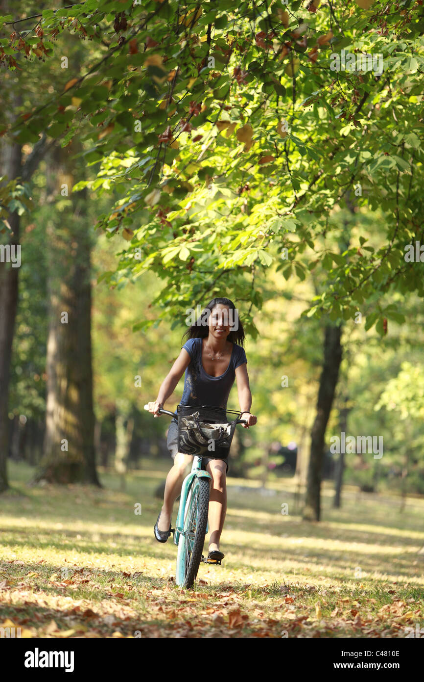 Young woman riding a bicycle in an early autumn forest Stock Photo - Alamy