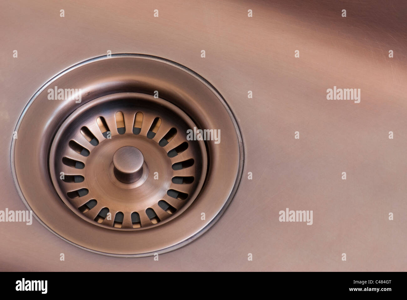 Dark bronze drain on bottom of the sink Stock Photo - Alamy