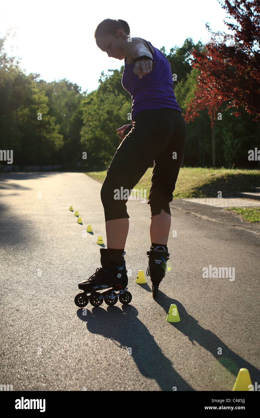 Teenage girl roller blading through slalom cones Stock Photo - Alamy