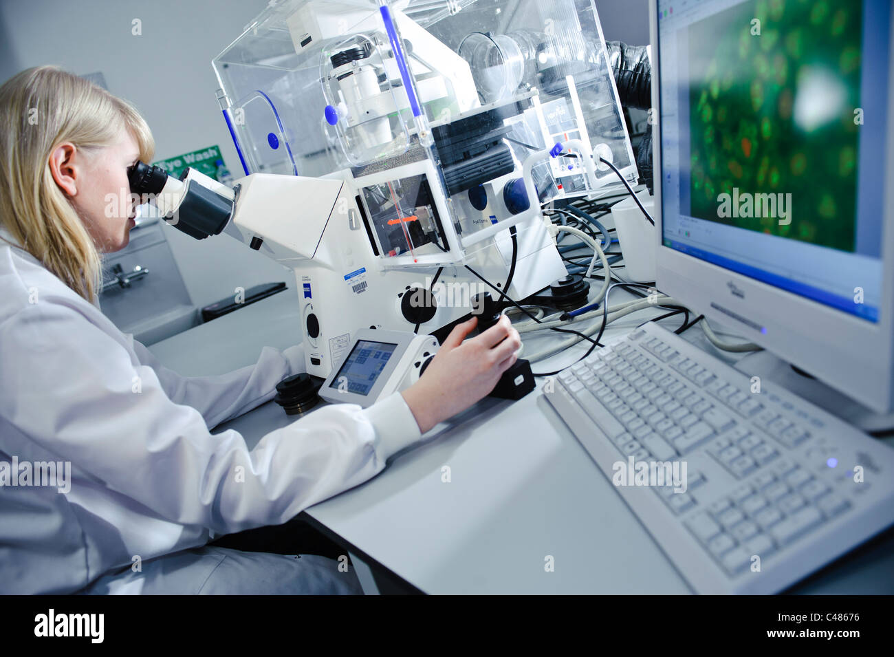 Young blond female scientist white lab coat powerful microscope in well ...