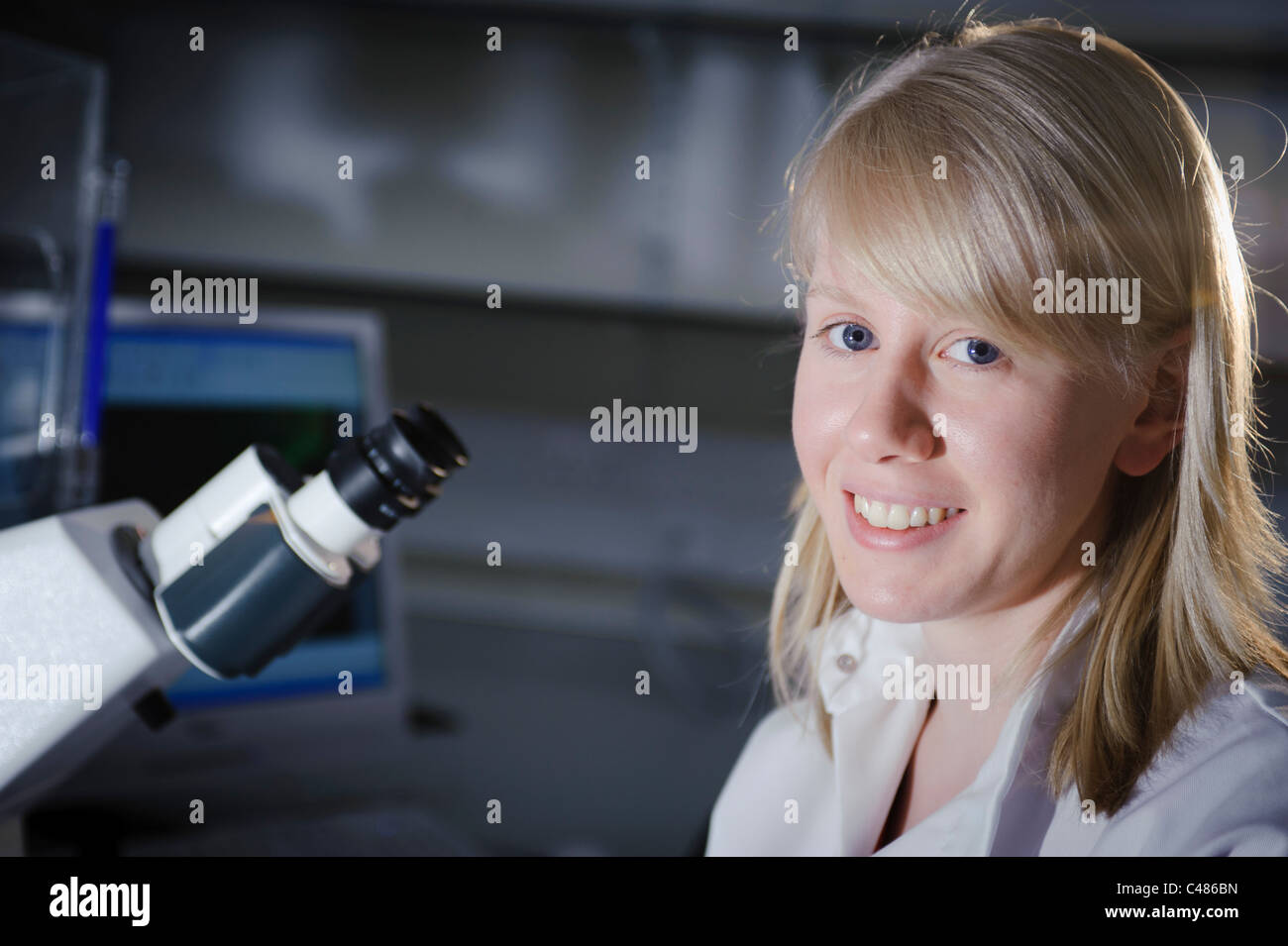 Young blond female scientist white lab coat powerful microscope in well ...