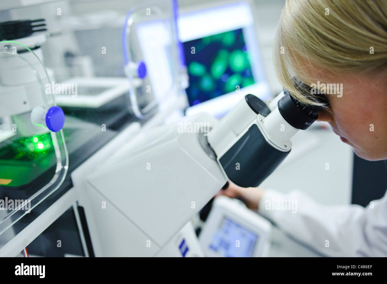 Young blond female scientist white lab coat powerful microscope in well ...