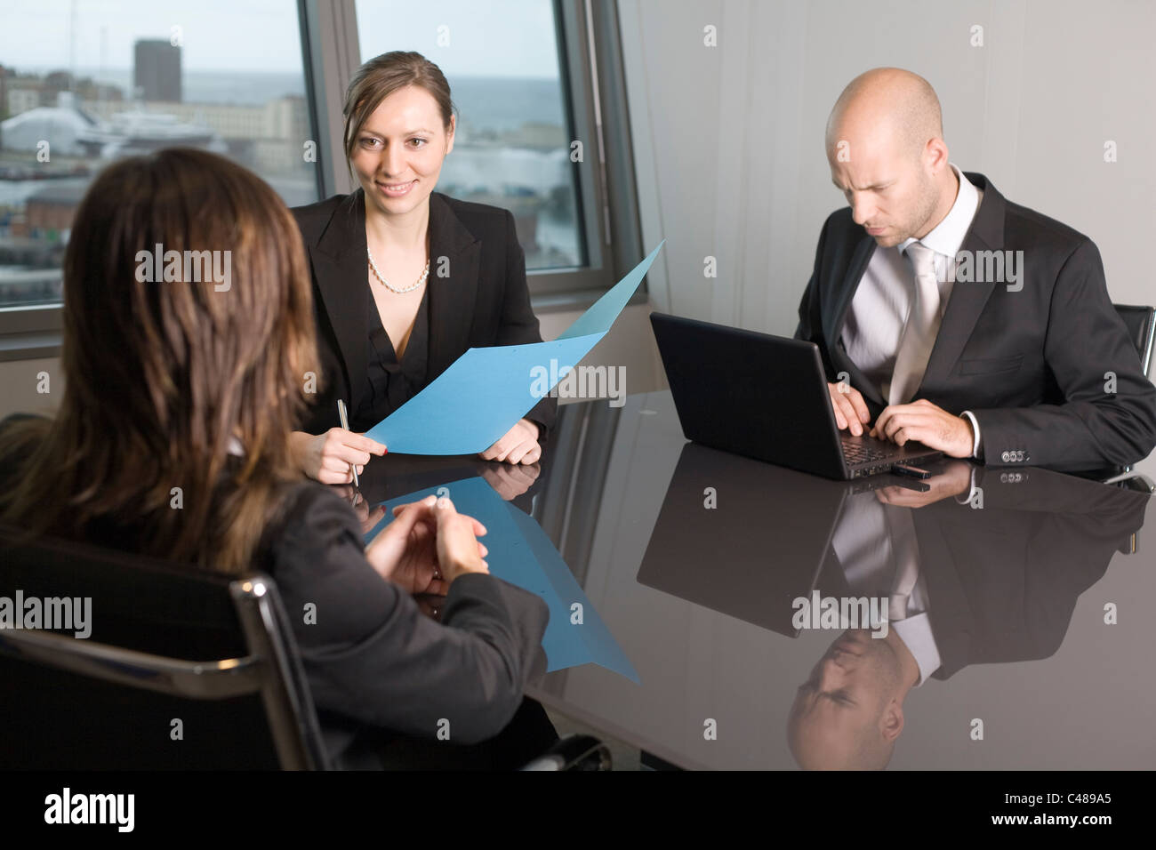 Three persons during a interview in a skyline office Stock Photo - Alamy