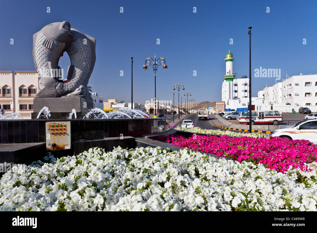 A two fish statue on a roundabout decorated with flowers in Muscat ...