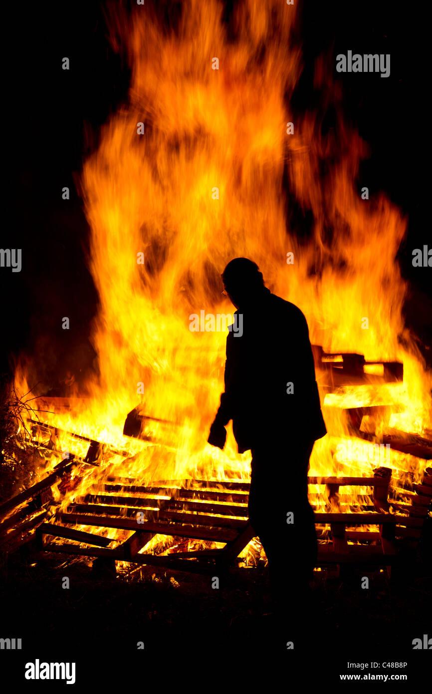 Man silhouetted against a roaring bonfire Stock Photo - Alamy