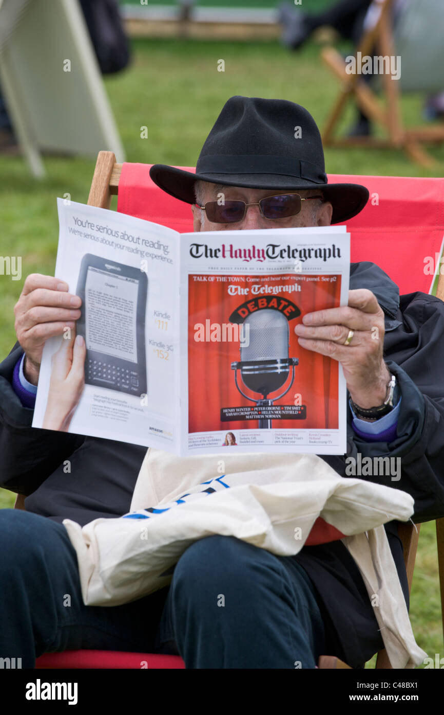 Man reading Telegraph magazine sitting in deckchair at Hay Festival ...