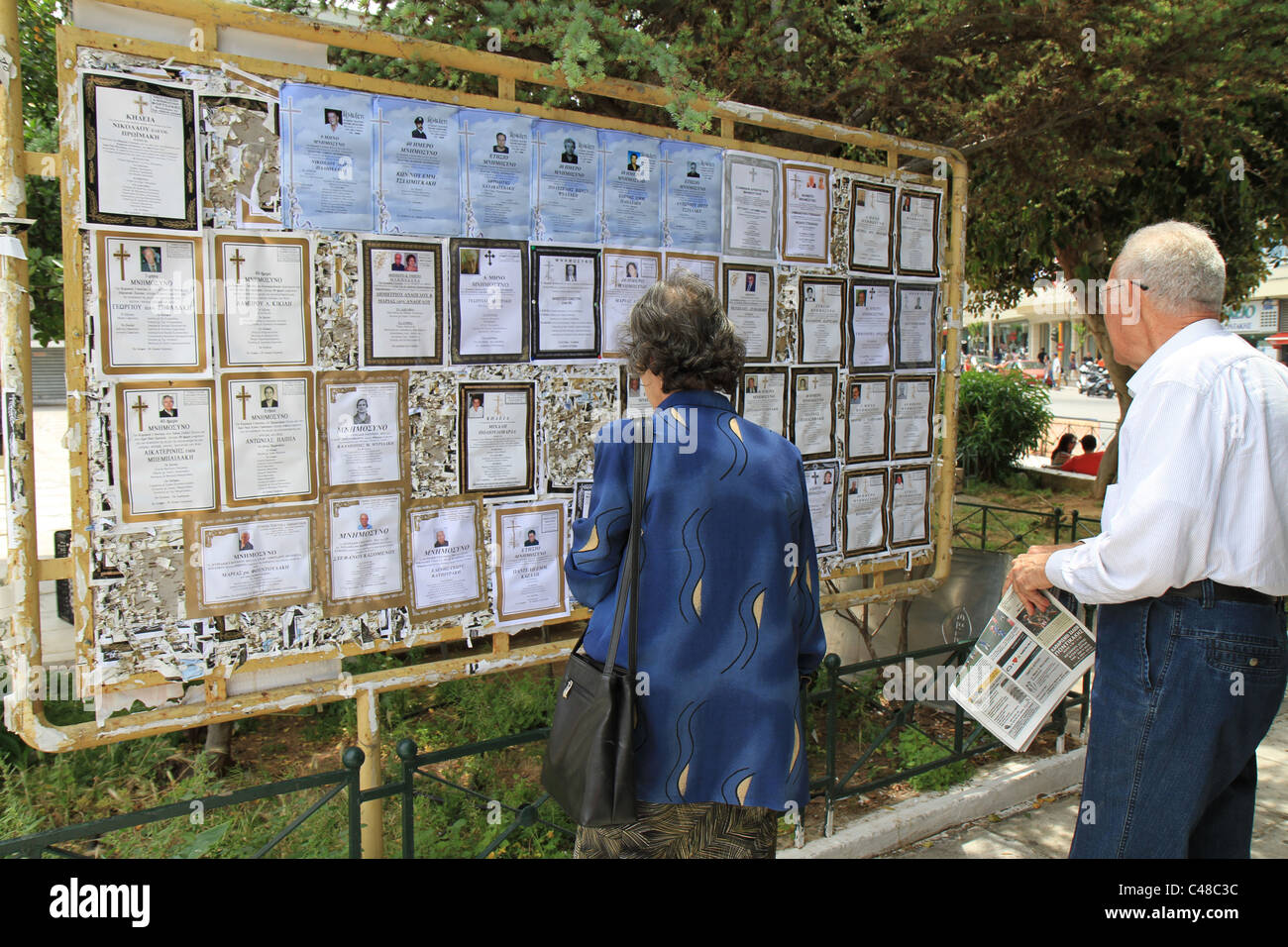 Two elderly people looking at orbituaries in Chania, Crete, Greece ...
