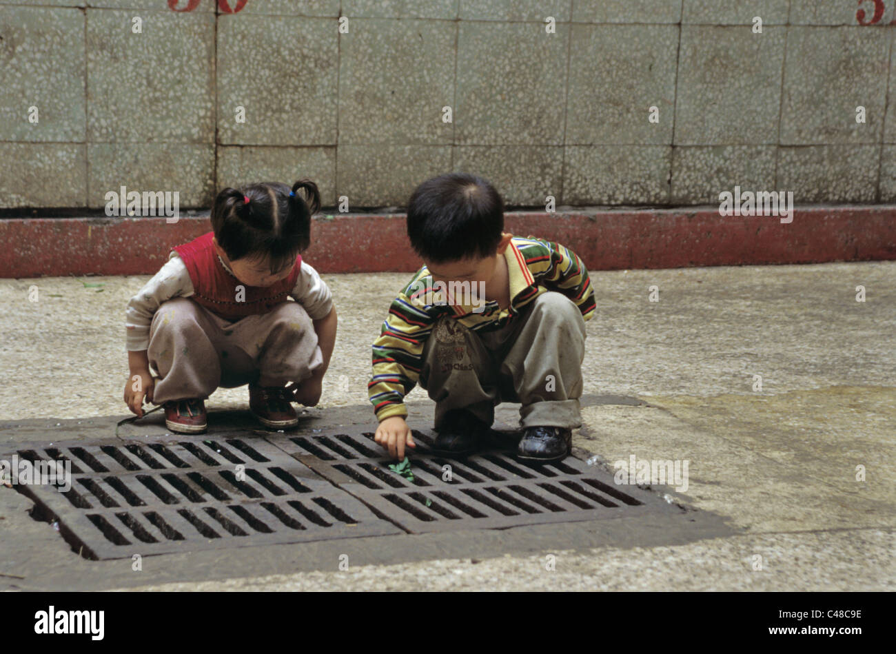 Covered food market, kids playing in drain, Chongqing, China 990602 ...