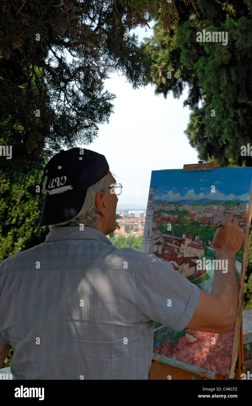 Local artist Walter Ferrari painting the iconic view of Verona Stock ...