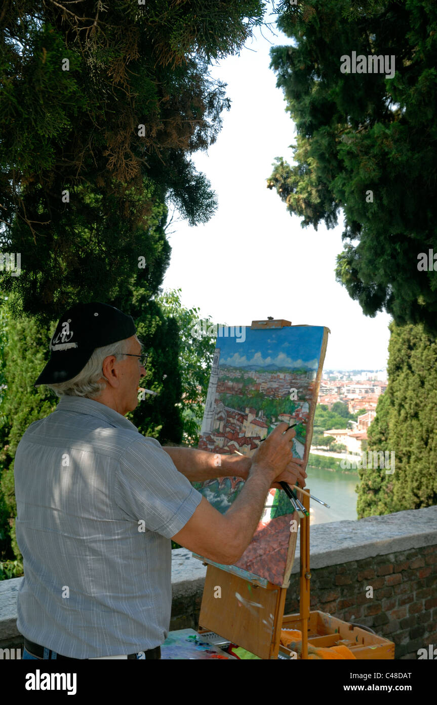 Local artist Walter Ferrari painting the iconic view of Verona Stock ...