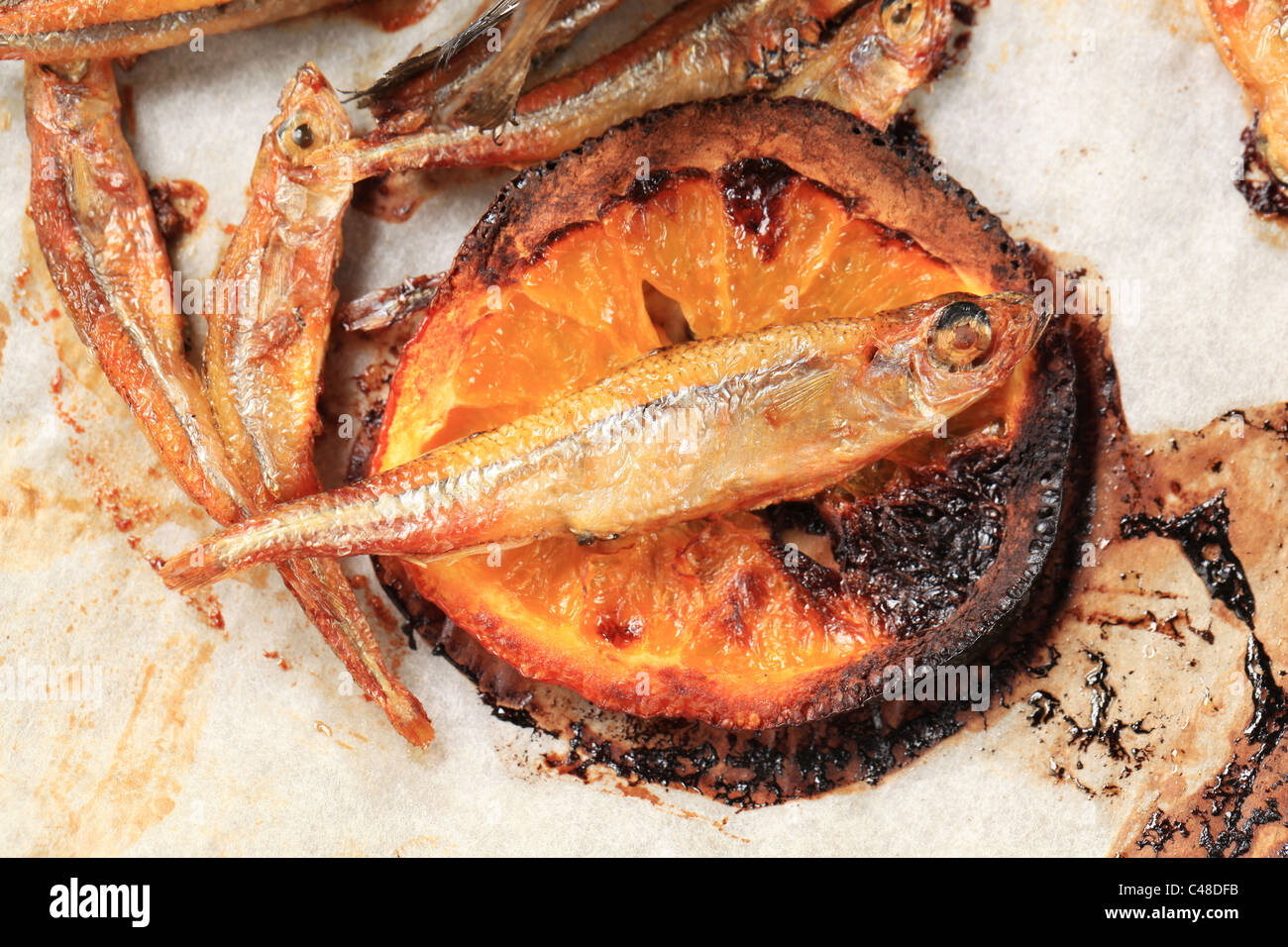 Spicy fried anchovies and slice of lemon - detail Stock Photo - Alamy