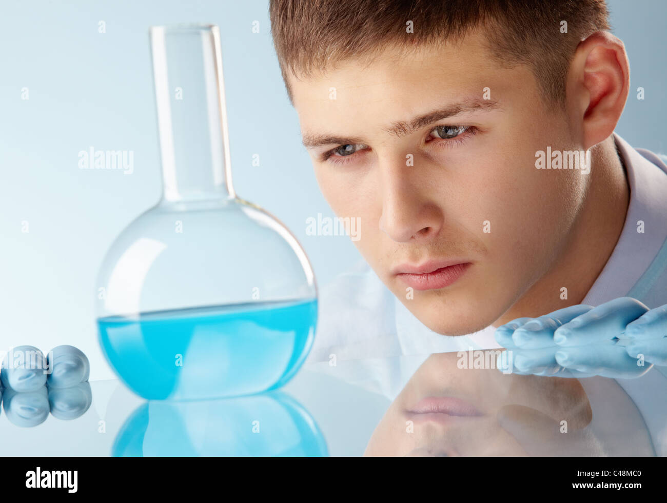 Serious chemist looking flask substance hi-res stock photography and ...