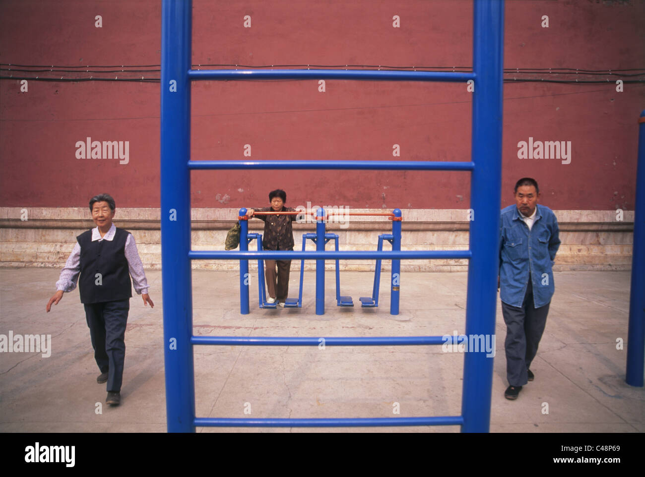 Photograph of three Chinese people doing exercises in a community ...