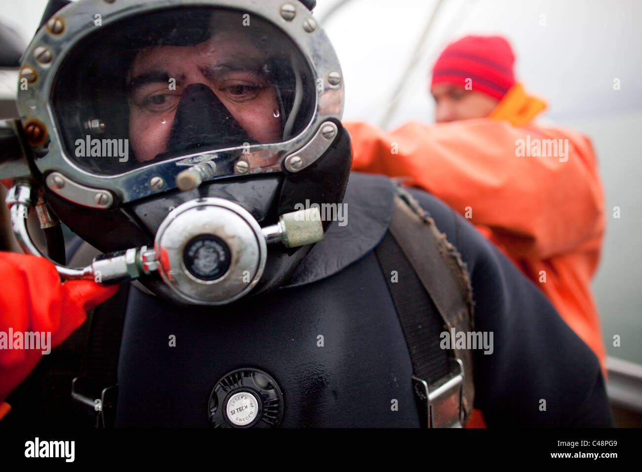 Tribal deckhand helps prep a geoduck diver for a dive in Puget Sound ...