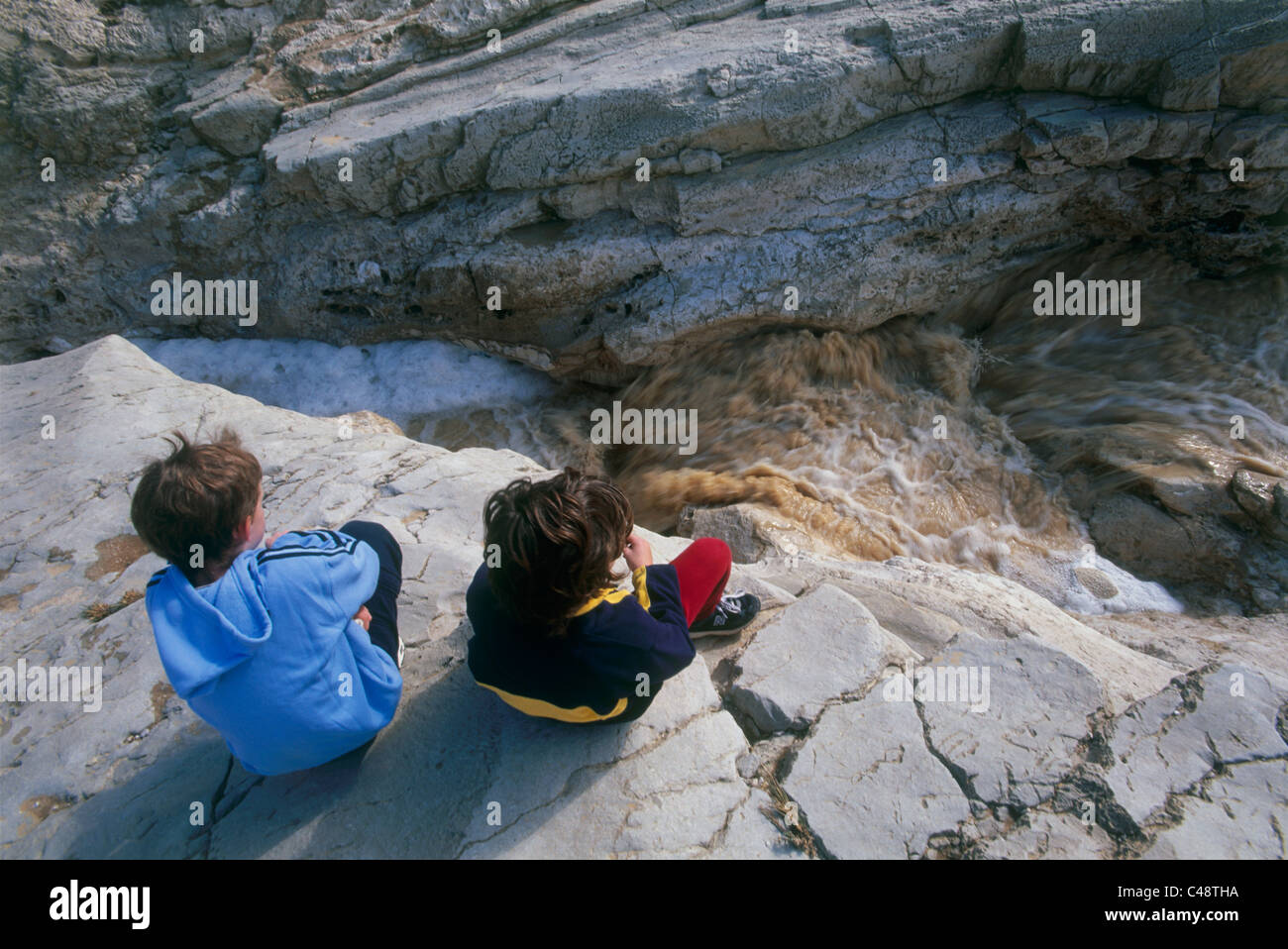 Two children sitting by the Dead Sea Stock Photo - Alamy