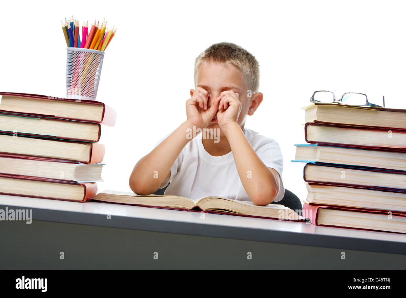Portrait of sleepy lad rubbing eyes showing his being tired of reading ...
