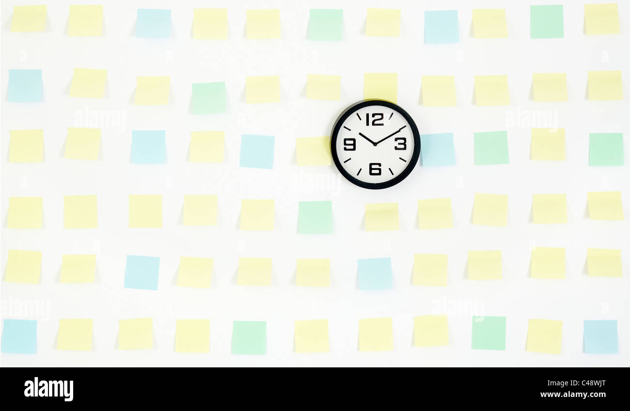 note papers and clock on an office wall Stock Photo - Alamy