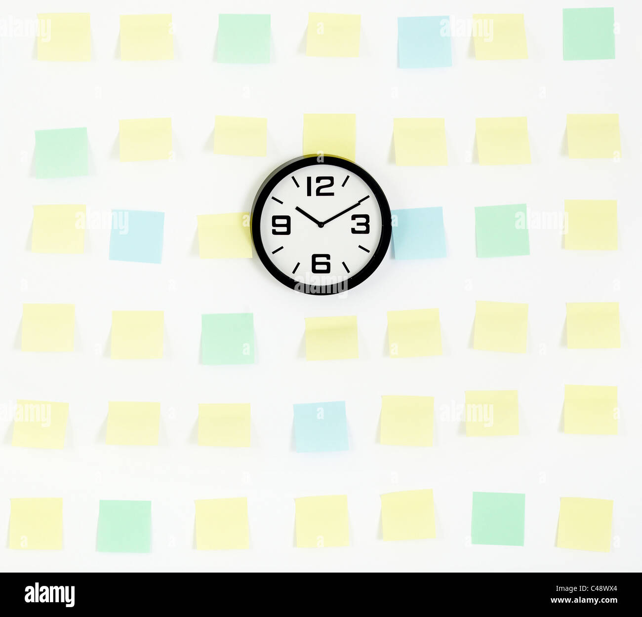 note papers and clock on an office wall Stock Photo - Alamy