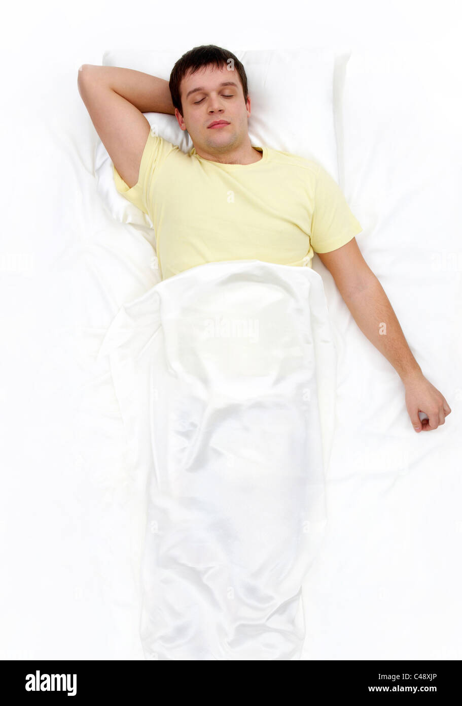 Above view of man with one hand under his head sleeping in cosy bed ...