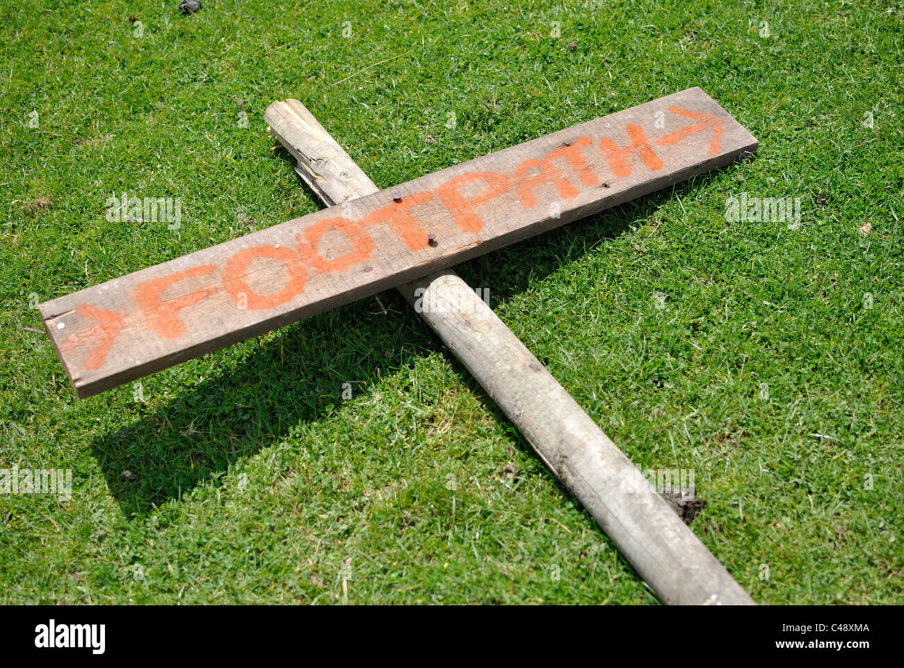 A fallen hand painted footpath sign Stock Photo - Alamy