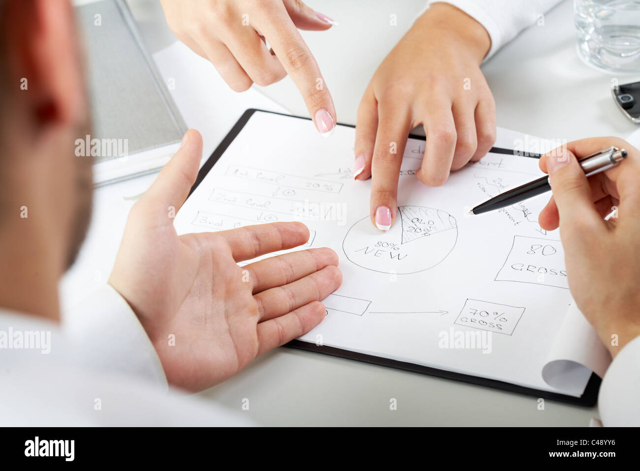 Close-up of team working with documents at business meeting Stock Photo ...