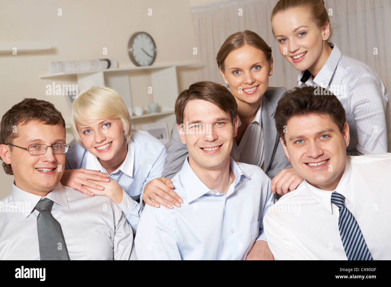 Portrait of friendly business people standing next to each other and ...