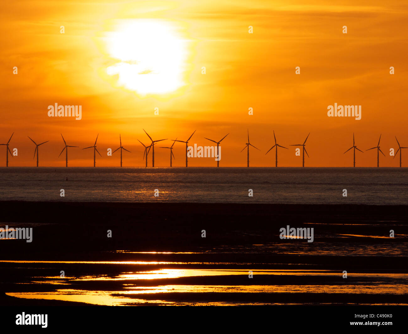 Wind farm with the sun setting in the background Stock Photo - Alamy