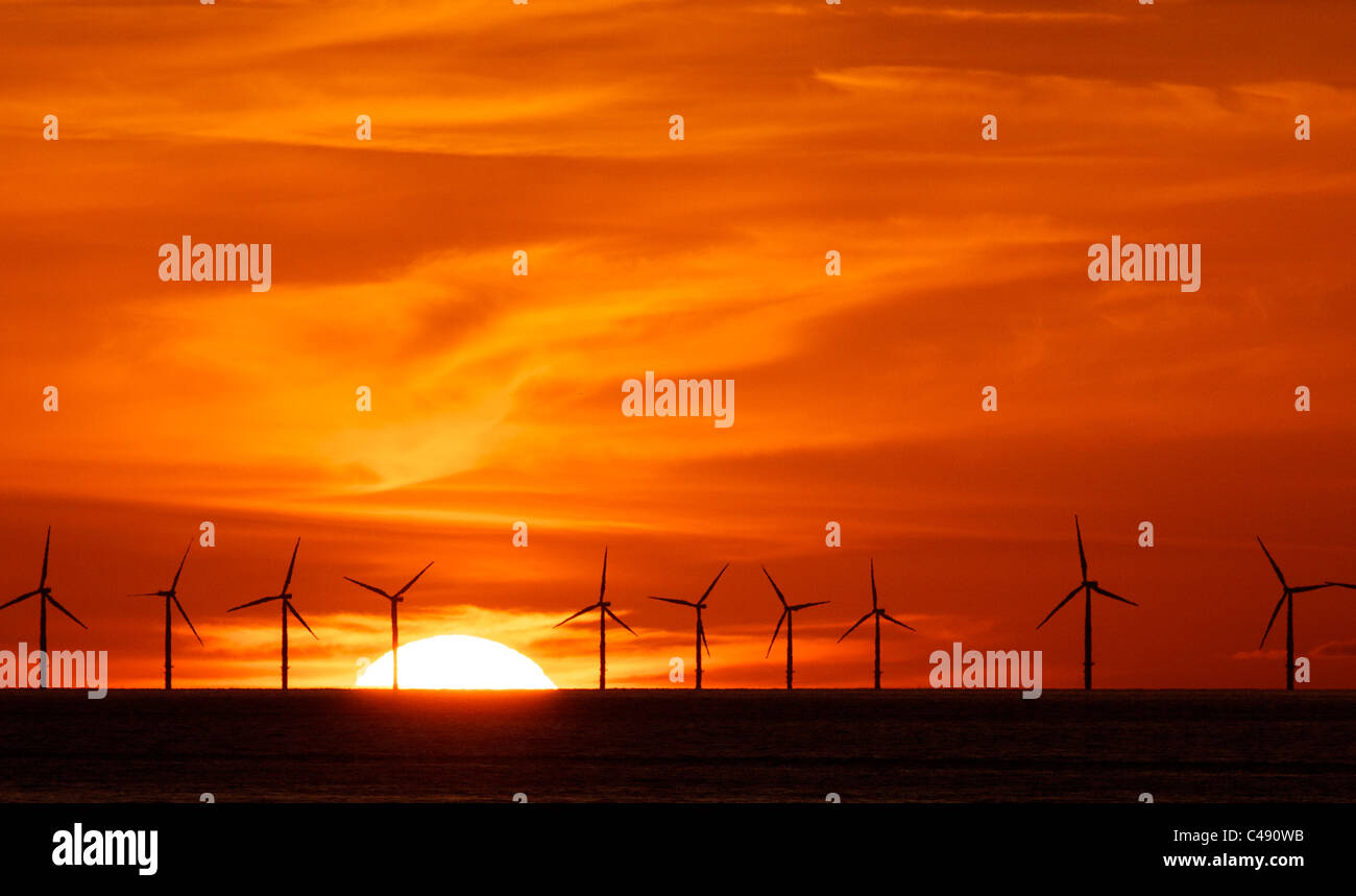 Wind farm with the sun setting in the background Stock Photo - Alamy