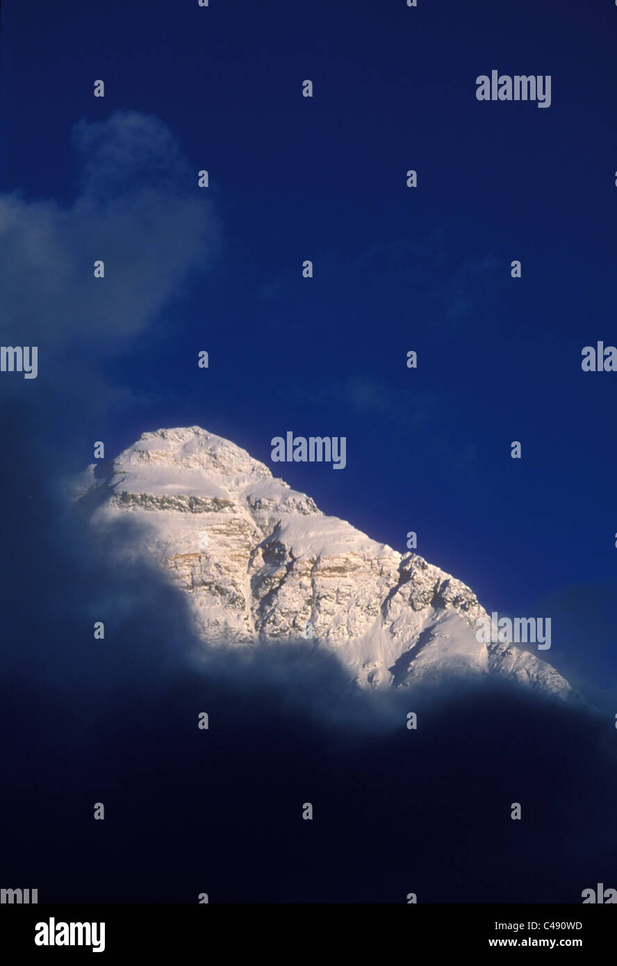 A massive snow covered mountain shining with alpine glow at sunset ...