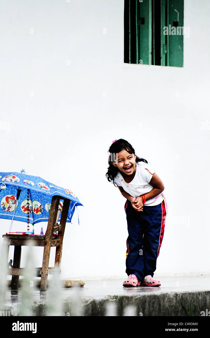 A local girl bursts out laughing whilst playing on her own in her ... A local girl bursts out laughing whilst playing on her own in her ...