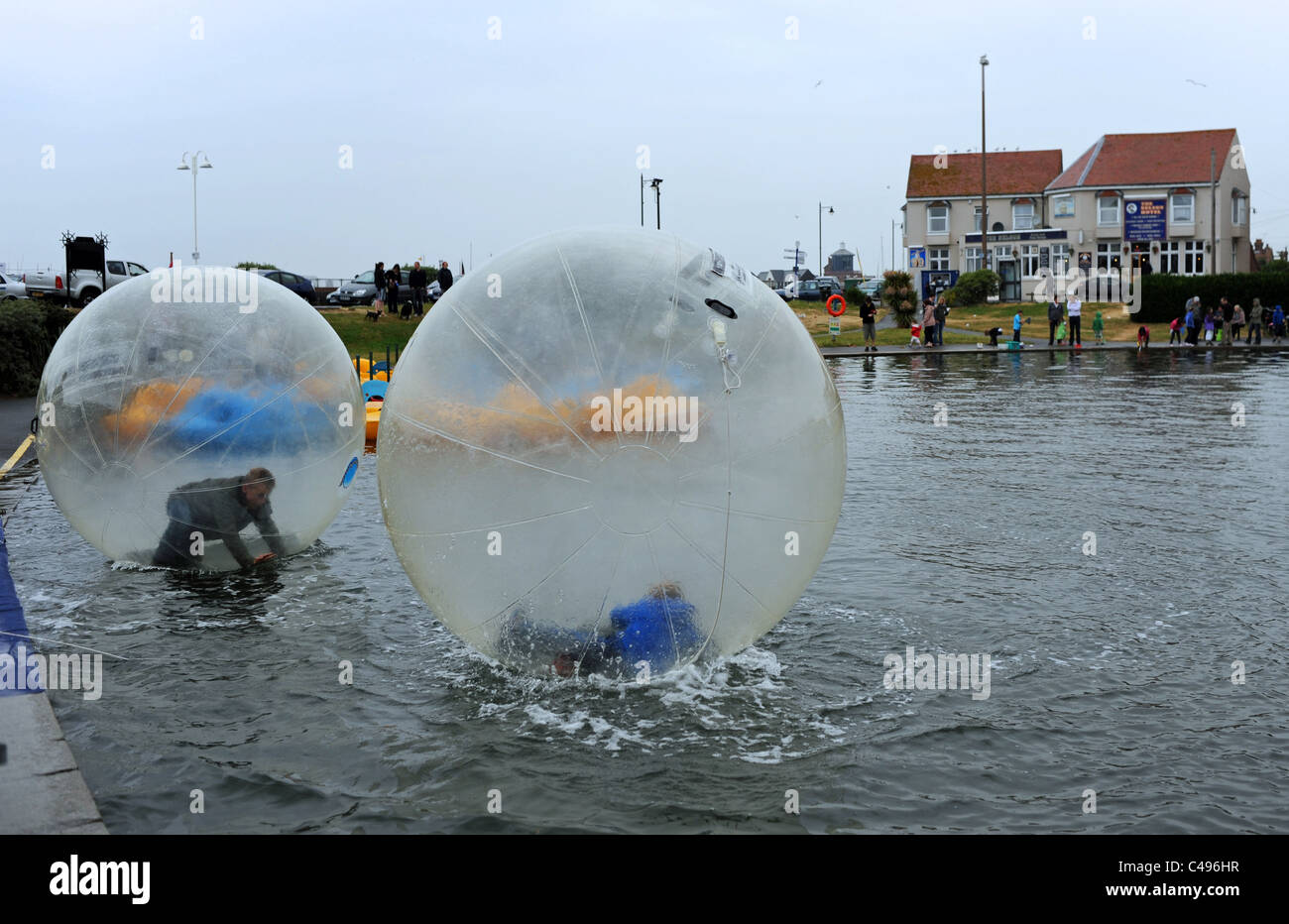 Youngsters enjoying themselves in the sphere balls on the Oyster Pond ...