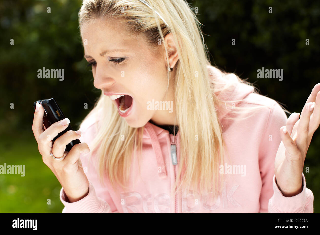 Woman shouting at her phone Stock Photo - Alamy