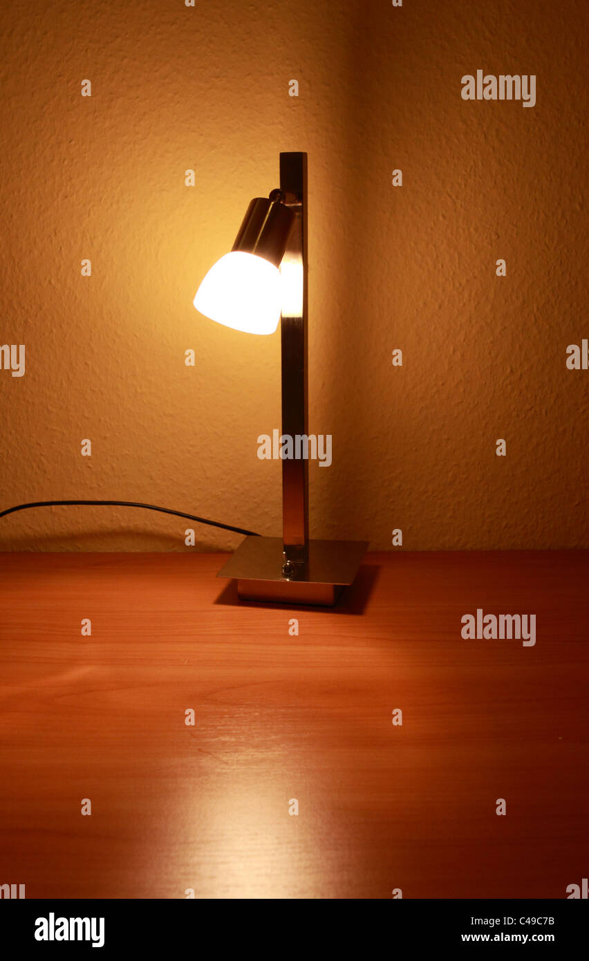 switched on light on the table in the dark Stock Photo - Alamy
