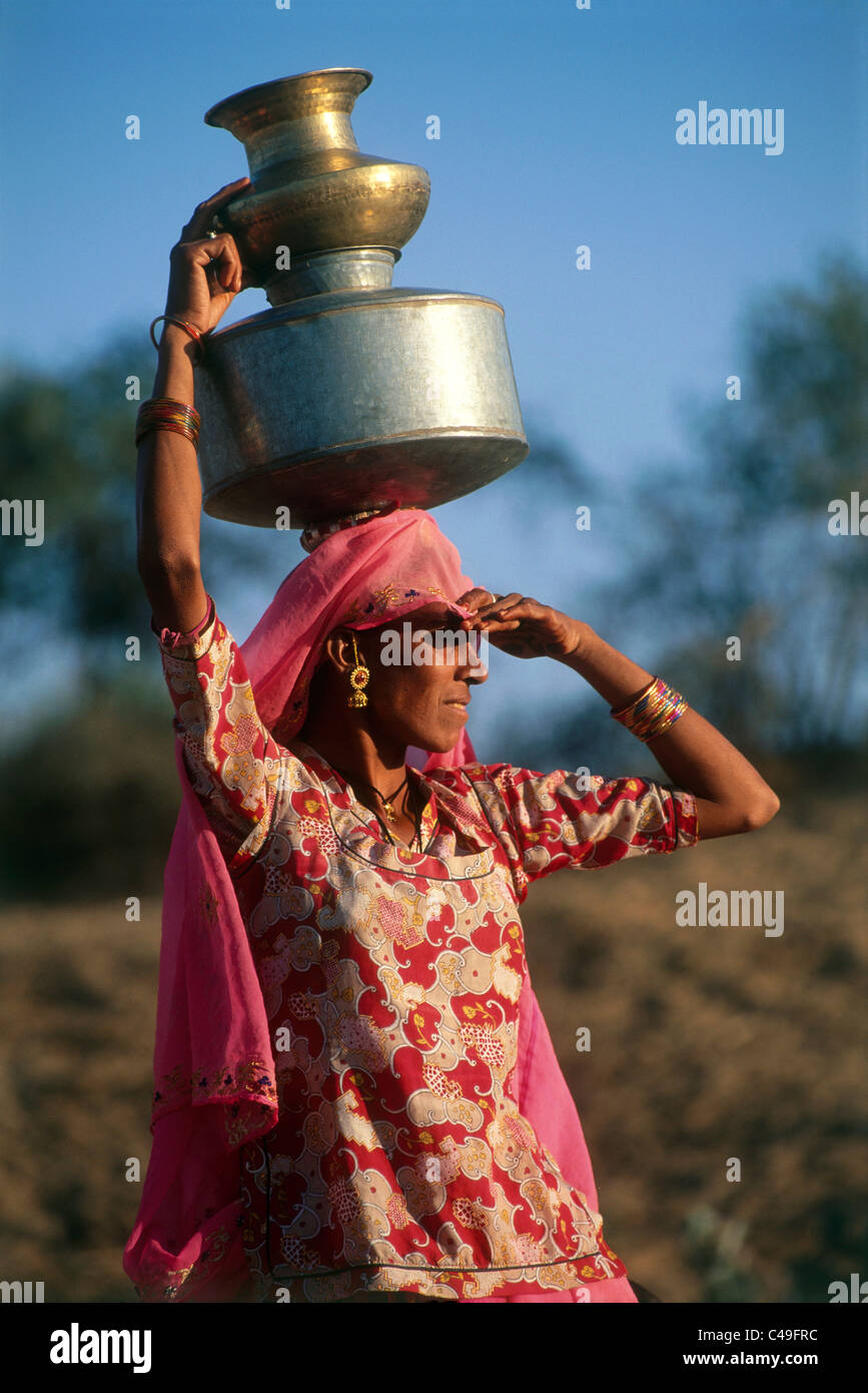 Photograph of a Indian woman with a big jar on her head on the way to ...