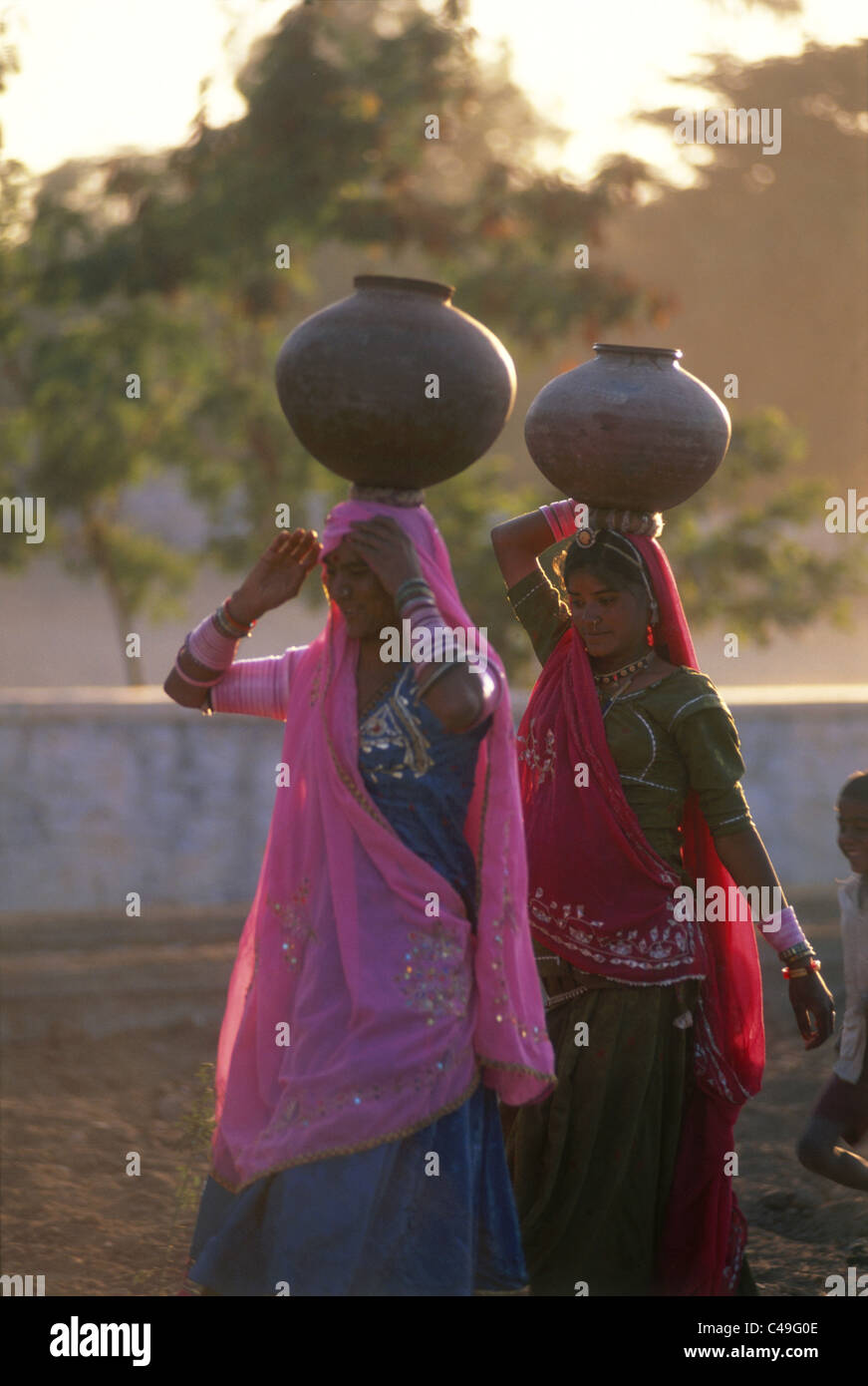 Photograph of two Indian women carrying water jars on their head on the ...