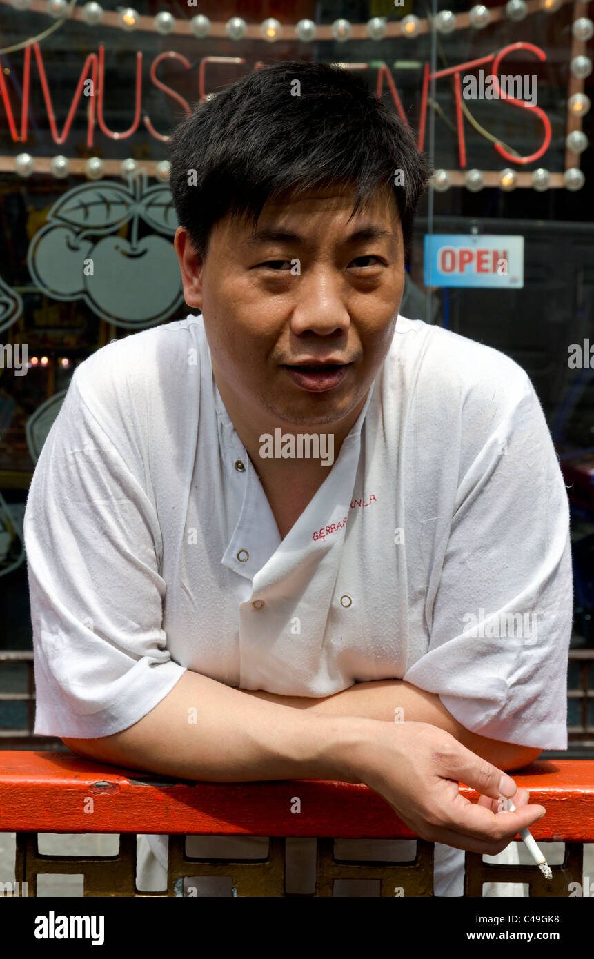 Portrait of Chinese cook taking a break and smoking at lunchtime in ...