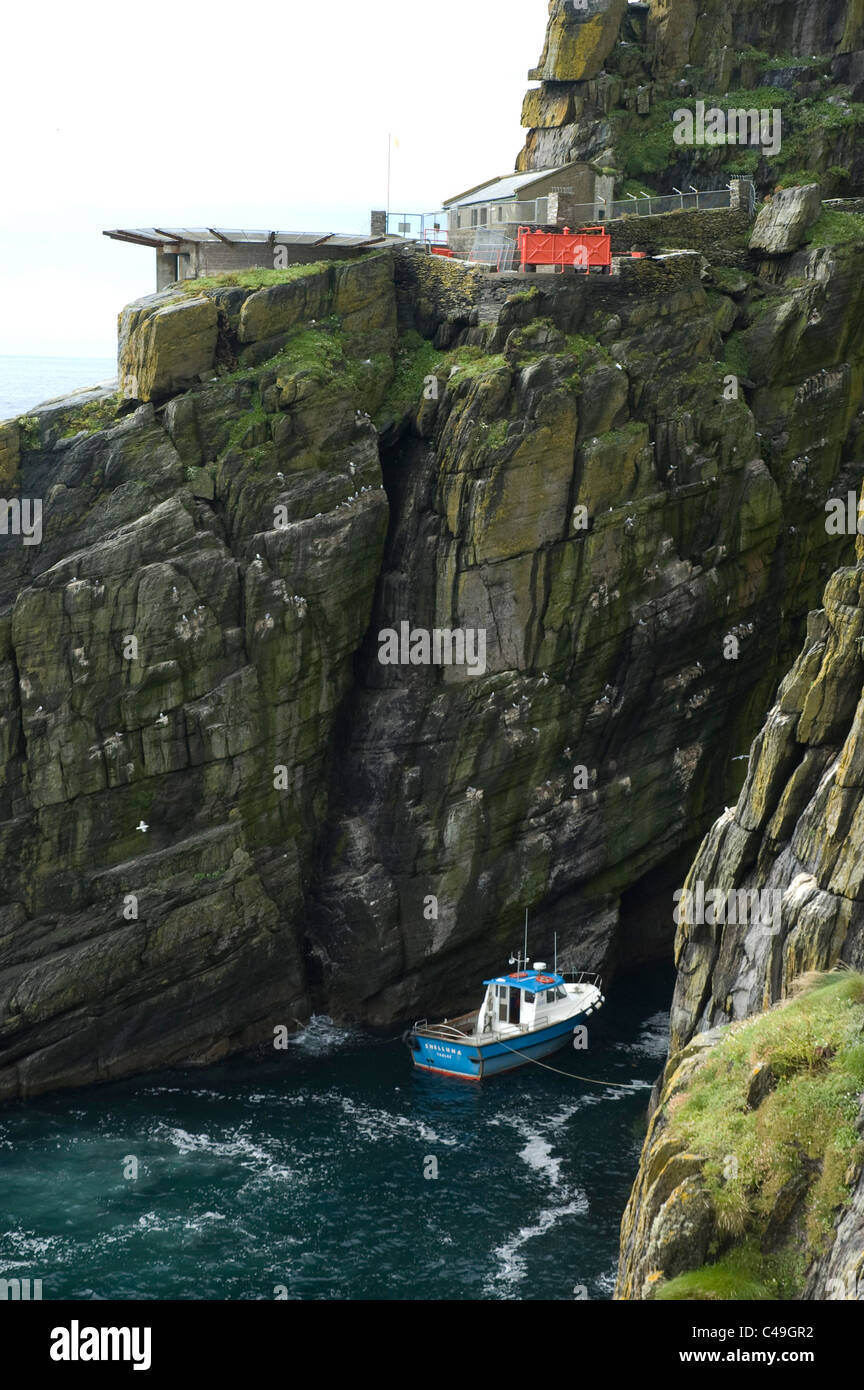 Photograph of a tied boat to a cliff in Ireland Stock Photo - Alamy