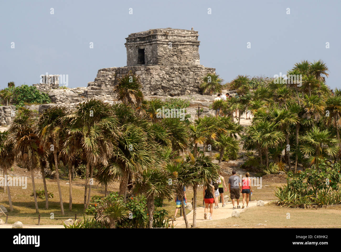 Tourists and Temple of the Wind God at the Mayan ruins of Tulum on the ...