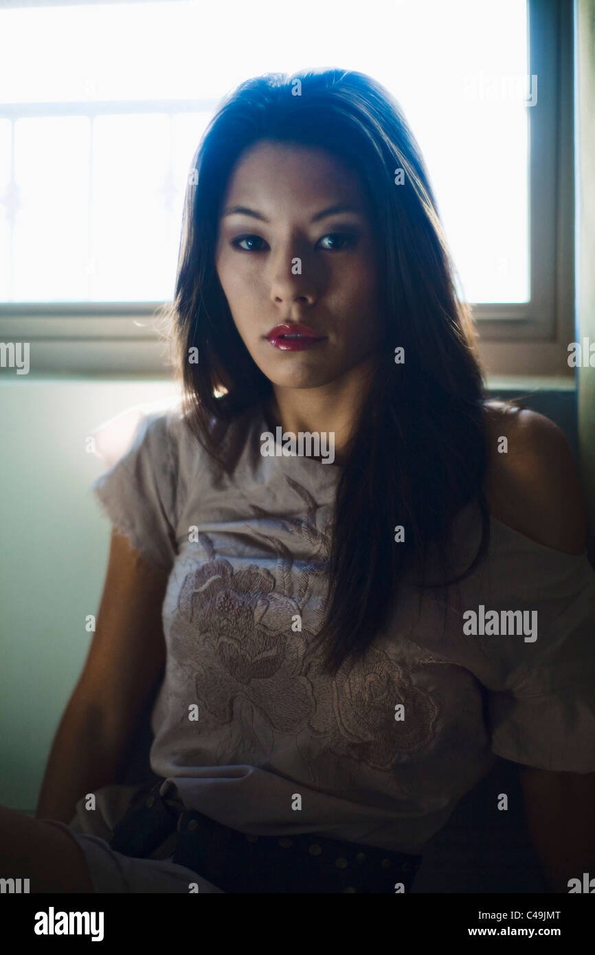Portrait of a woman sitting near a window Stock Photo - Alamy