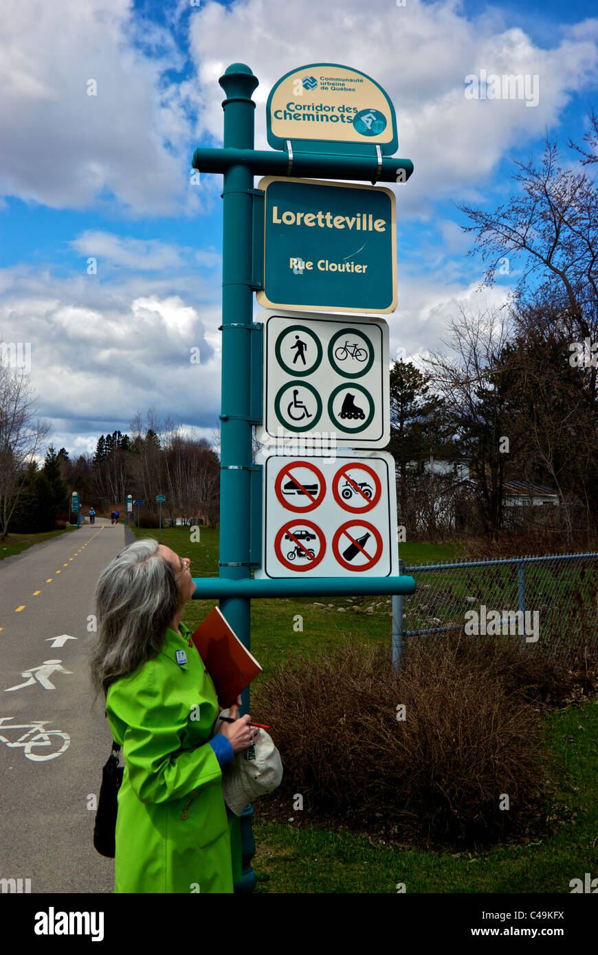 Woman looking at bicycle path sign in Huron Wendat First nations ...